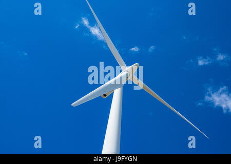 Single white wind turbine rising in a blue sky Stock Photo - Alamy