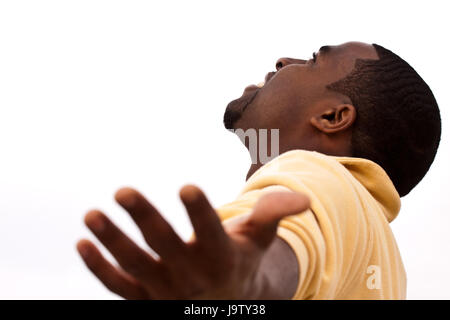 black man praying to god with arms outstretched looking up to the blue ...