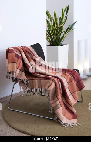 Throw draped over a chair Stock Photo - Alamy