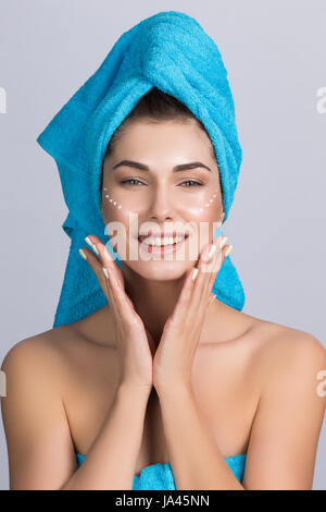 Beautiful woman with face cream on light green background, closeup ...