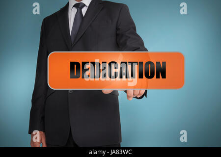 Businessman selecting the word dedication written on white tag on blue ...