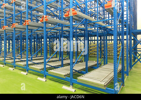 Dynamic storage with conveyer rollers in new warehouse Stock Photo - Alamy