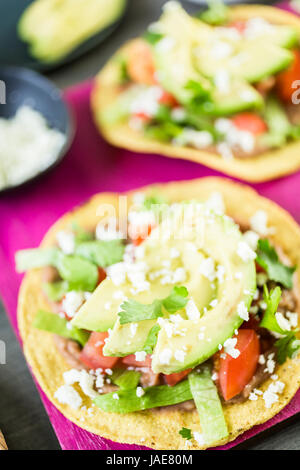 Traditional Mexican food tostadas on a clay or mud plate over a rusic ...