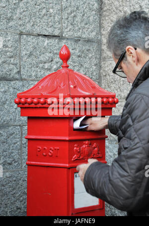 Man posting a letter in Victorian post box Stock Photo - Alamy