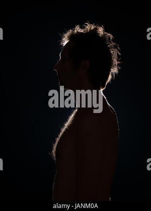 side view of man with back ligthing on black background Stock Photo - Alamy