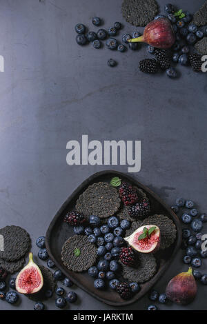 Fresh juicy figs and blackberries on a dark background. Harvesting ...