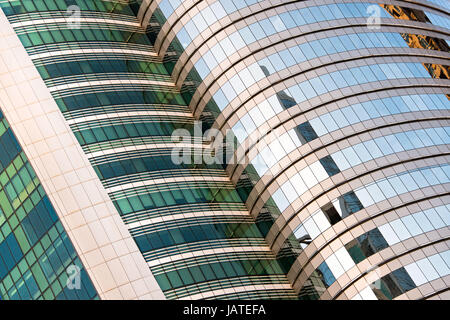 Abstract reflections of buildings in the curved green glass façade of ...