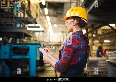 Young woman engineer taking notes in notebook Stock Photo - Alamy
