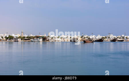 View of a part of the city of Sur with some traditional Arabic dhows in ...