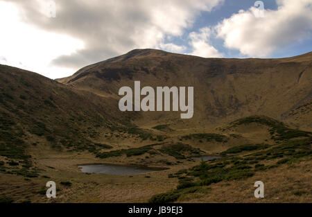 Oval lake at the foot of the mountain Stock Photo - Alamy