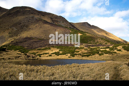 Oval lake at the foot of the mountain Stock Photo - Alamy