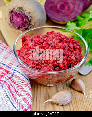 Beet caviar in the glass bowl, garlic, beets, parsley, napkin on the ...