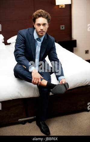 Tired business man removing shoes in hotel room Stock Photo - Alamy