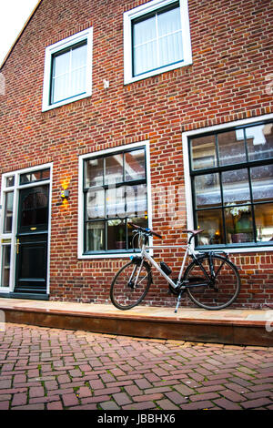 a house with a bike parked next to it on the sidewalk in front of the ...