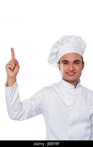 Young male chef pointing upwards while staring at something Stock Photo ...