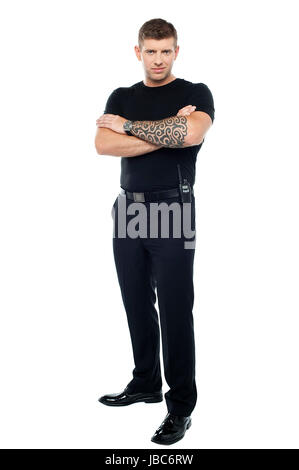 Tough serious bouncer or bodyguard with crossed arms staring at camera ...