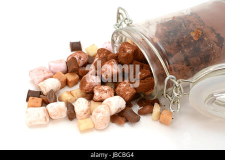 Marshmallows, fudge, chocolate, fudge and cocoa spill from a glass jar ...