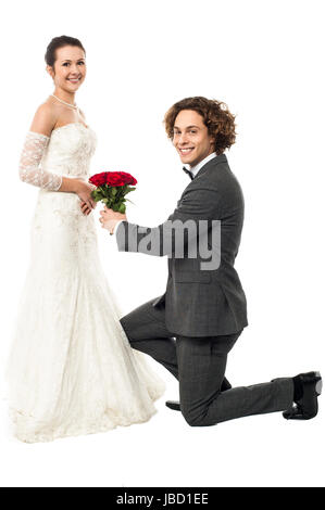 Handsome guy on his knees proposing girl to marry him holding hands of ...