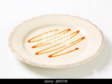 Caramel drizzle sauce decoration on plate Stock Photo - Alamy