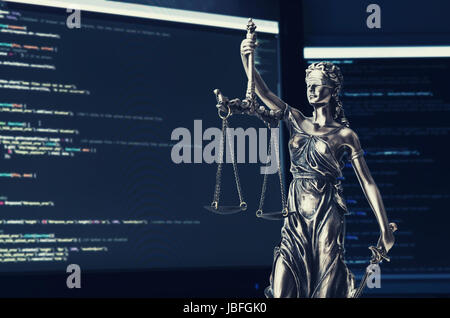 Justice statue with code on screen in background. Internet crime ...