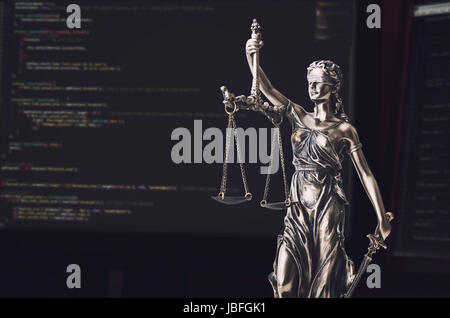 Justice statue with code on screen in background. Internet crime ...
