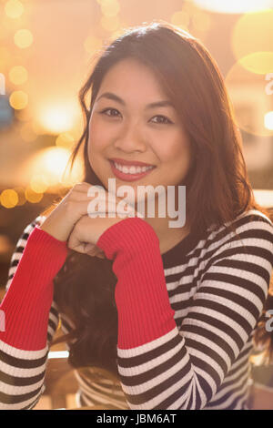 Happy smiling woman wearing striped casual style sweater, pointing finger to the right with ...