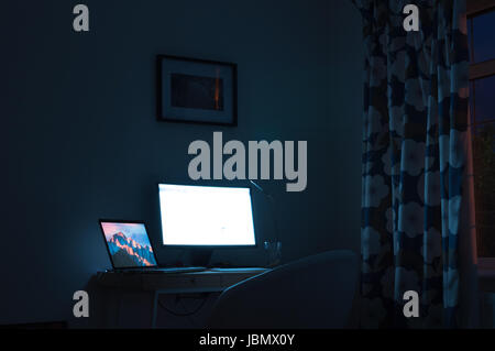 Computer screen illuminating room at night Stock Photo - Alamy