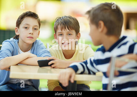 Portrait of positive and emotional schoolboy talking on phone, white ...