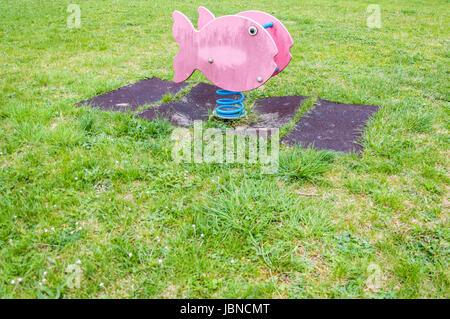 Old pink playground springer fish riding toy Stock Photo - Alamy