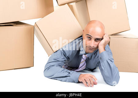 Bored businessman under a pile of cardboard boxes Stock Photo - Alamy