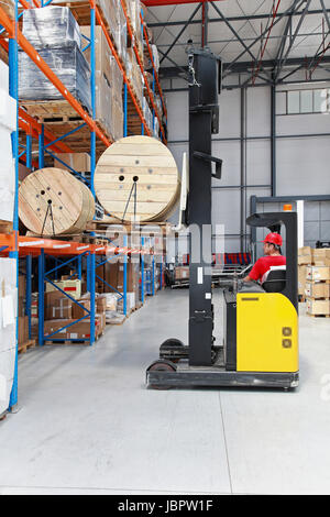 Forklift loading pallet with roll in distribution warehouse Stock Photo ...