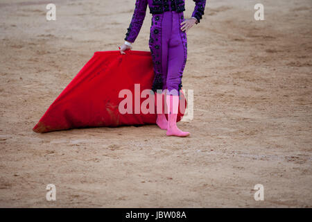 A barefoot bullfighter waits the bull with the capote during a ...