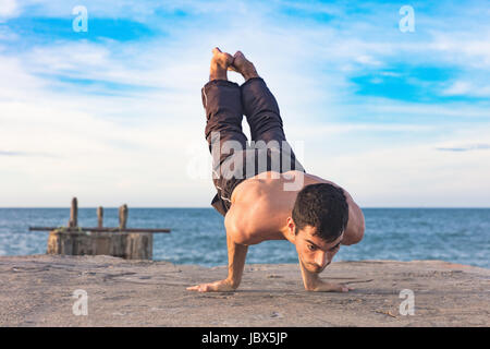 Man balancing on one hand on tall stack of chairs Stock Photo - Alamy