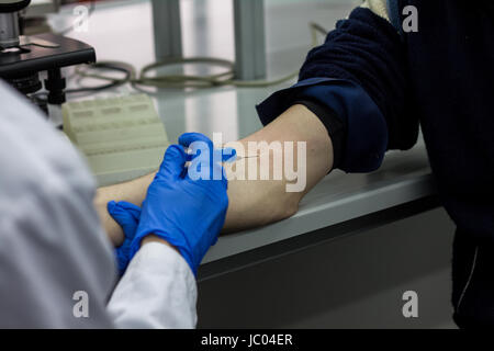 Doctor or scientist inject a needle in patient's arm Stock Photo - Alamy