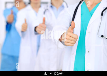 Group of doctors showing OK or approval sign with thumb up. High level ...