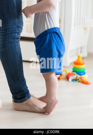 Baby standing on tiptoes reaching out, cute one year old infant on ...