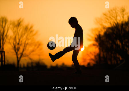 Boy Lifting Ball Stock Photo - Alamy