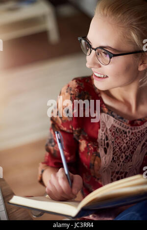 Beautiful business woman writting notes while standing near the office ...
