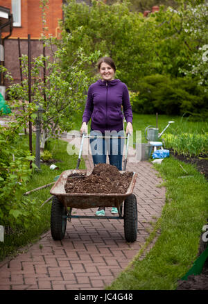 Image of beautiful woman gardener standing over plants in greenhouse ...