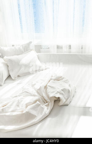 untidy bed against window Stock Photo - Alamy