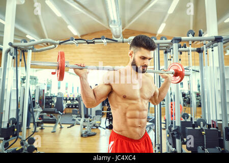 man makes exercises with bar in exercise room Stock Photo - Alamy