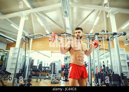 man makes exercises with bar in exercise room Stock Photo - Alamy