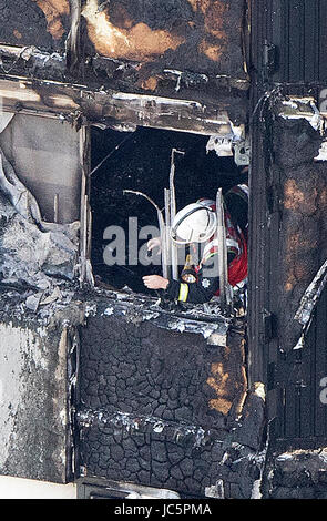 A firefighter investigates a floor after a fire engulfed the 24-storey ...