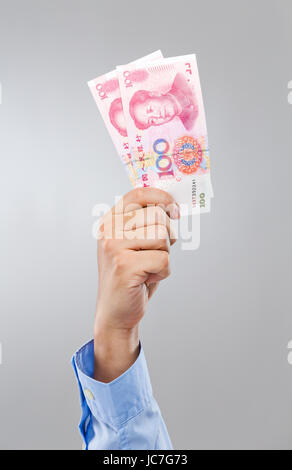 Male hand hold Chinese yuan or abbreviated RMB banknote, the official ...