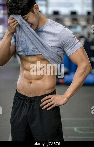 Young adult man wiping sweat from his forehead, catching his breath and ...