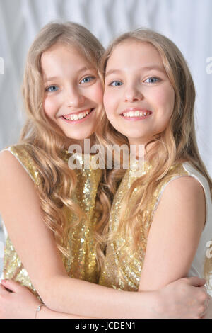 Portrait of happy twin sisters touching their hands Stock Photo - Alamy