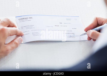 A Male Hand Filling Out The Amount On A Cheque Stock Photo - Alamy
