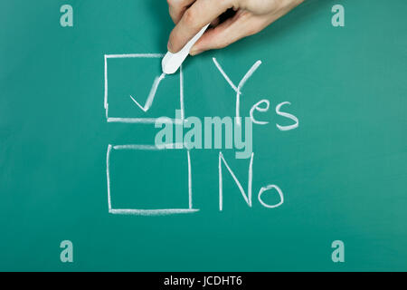 Hand holding chalk making a yes choice Stock Photo - Alamy