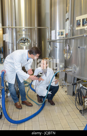 scientist team behind metal gauge in the factory Stock Photo - Alamy