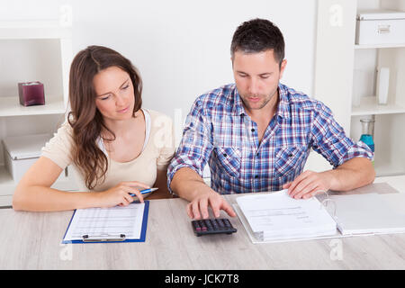 An attractive senior couple calculating their home expenses. Portrait ...